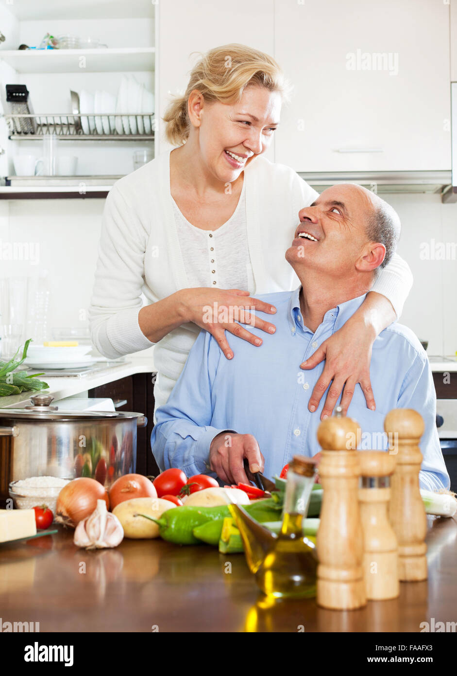 happy senior man helping his wife in the kitchen Stock Photo - Alamy