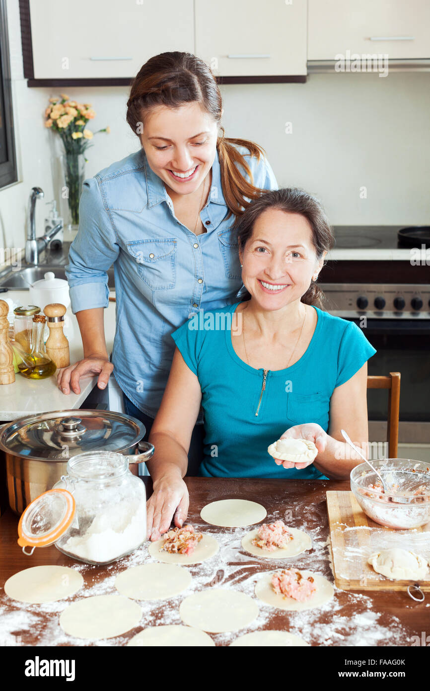 Two women cooking meat pasties at home kitchen Stock Photo - Alamy