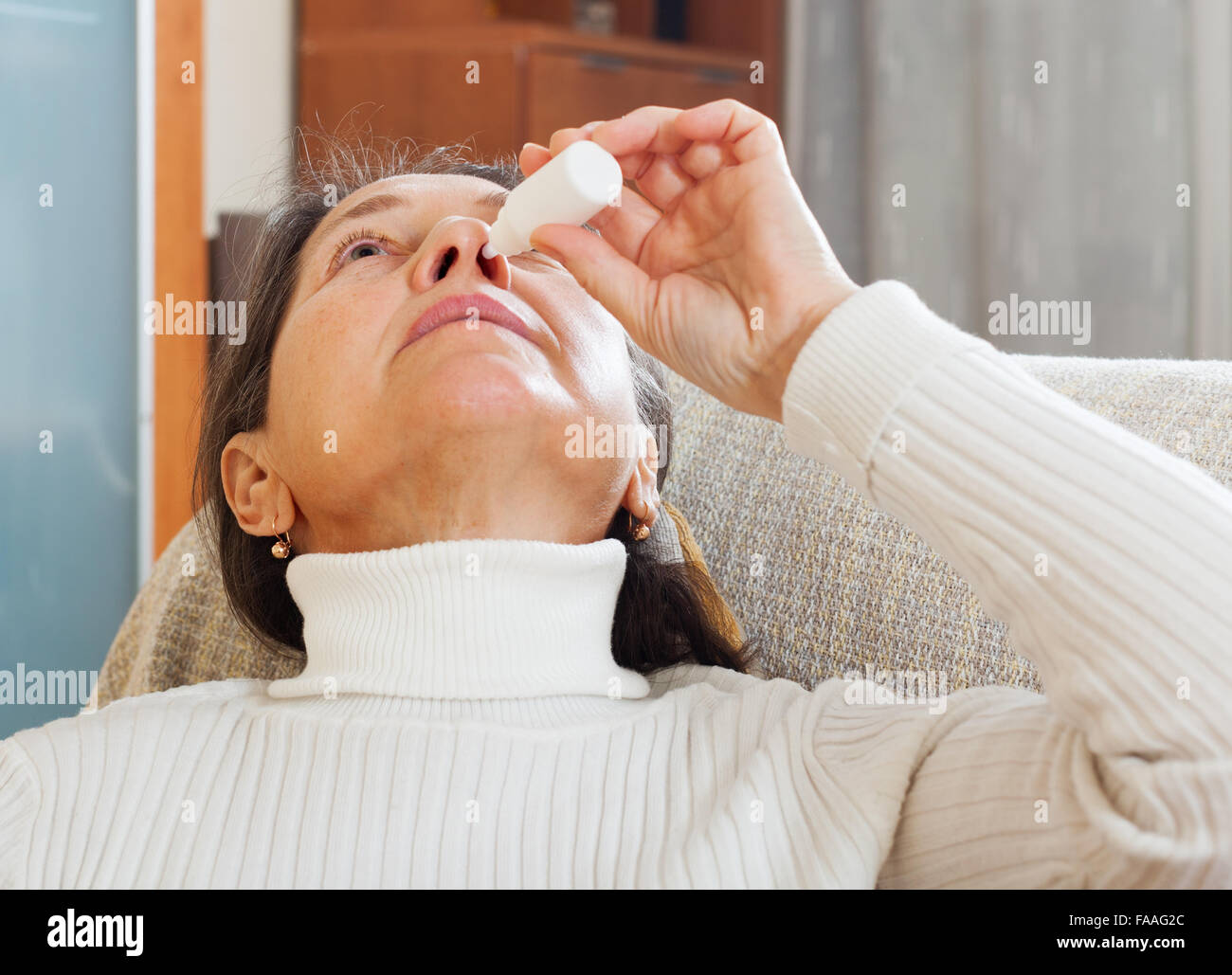 Mature woman dripping nasal drops at home Stock Photo - Alamy