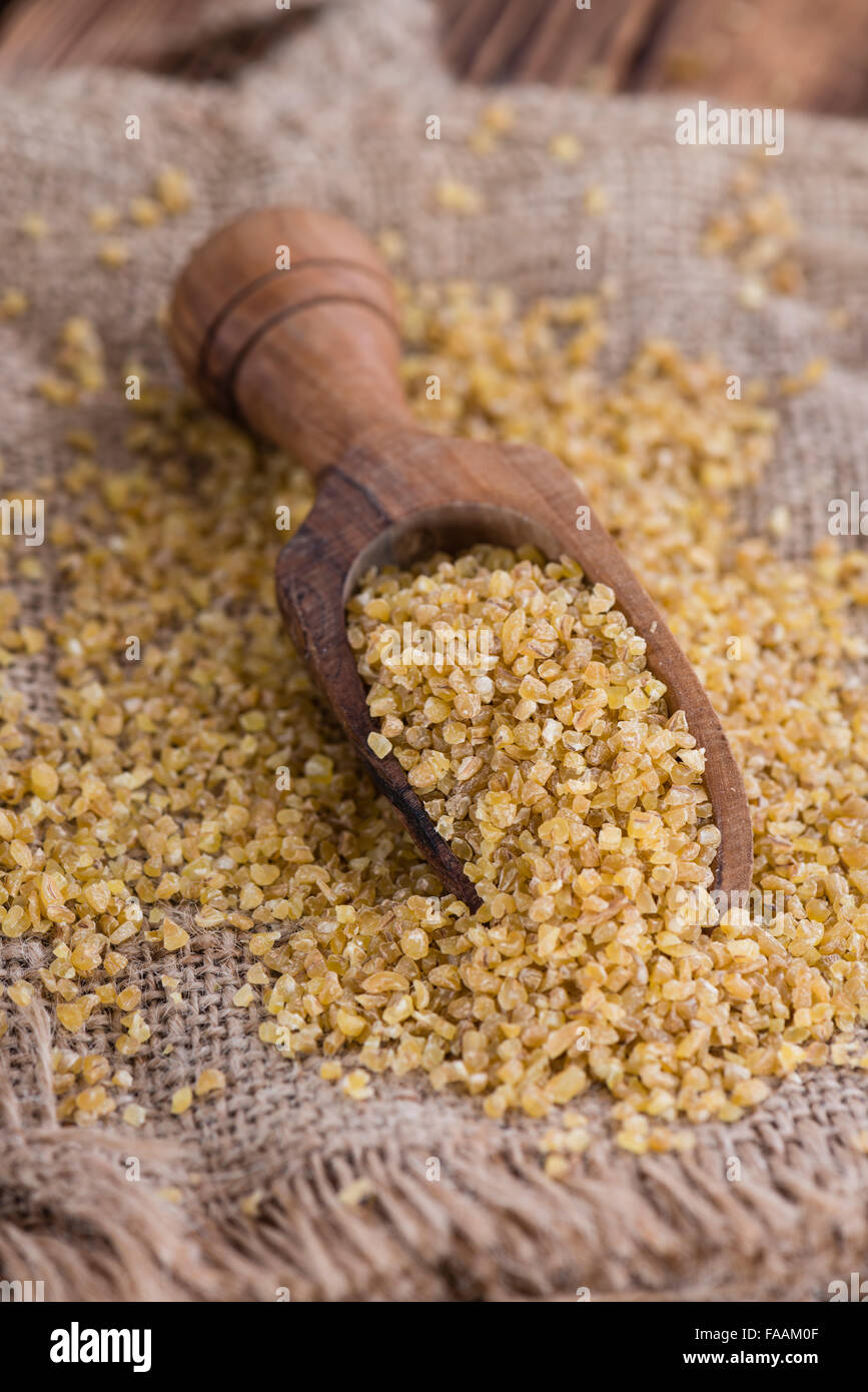 Raw Bulgur (on wooden background) as detailed close-up shot Stock Photo ...