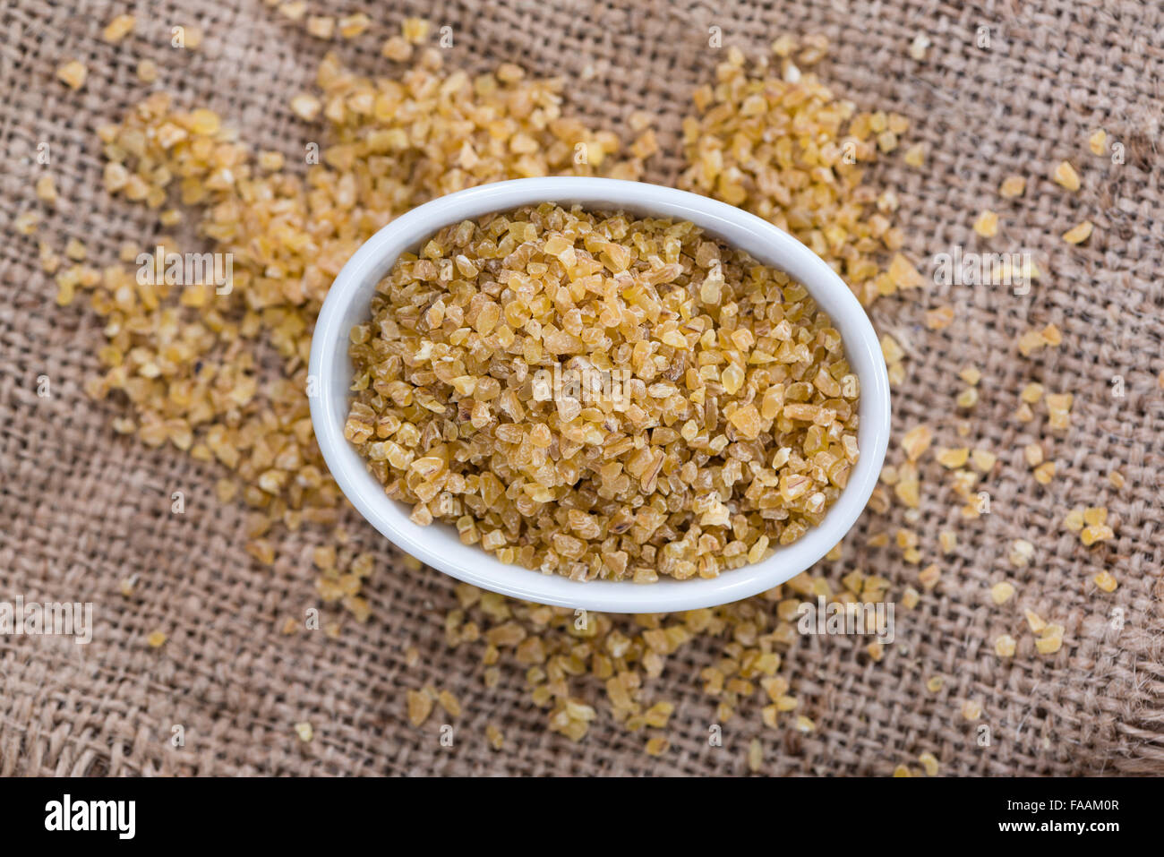 Raw Bulgur (on wooden background) as detailed close-up shot Stock Photo ...