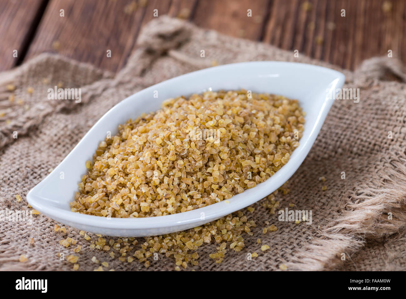 Portion of raw Bulgur (close-up shot) on wooden background Stock Photo ...