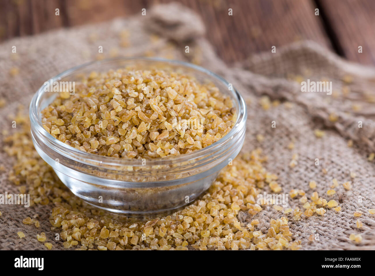 Raw Bulgur (on wooden background) as detailed close-up shot Stock Photo ...