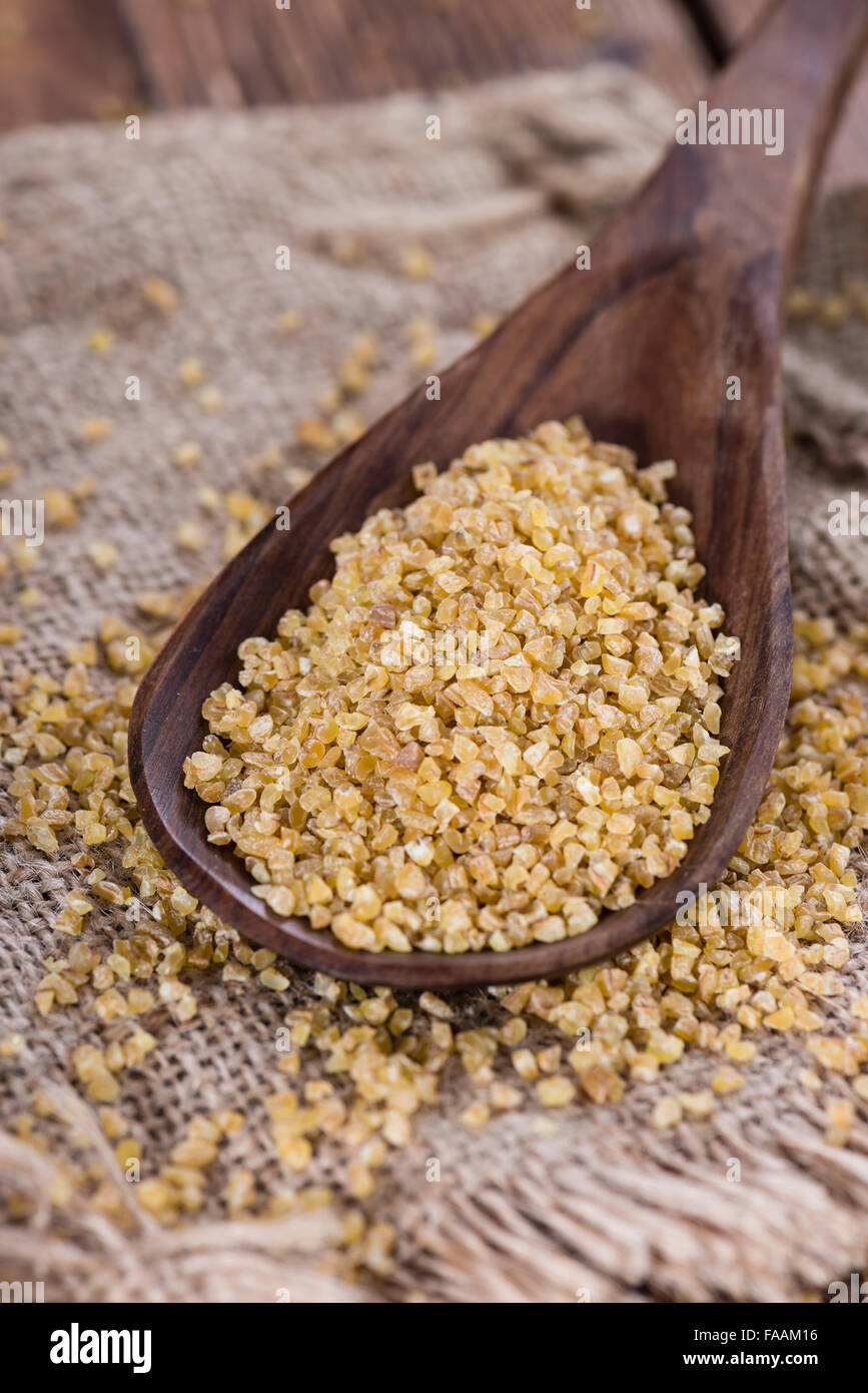 Raw Bulgur (on wooden background) as detailed close-up shot Stock Photo ...