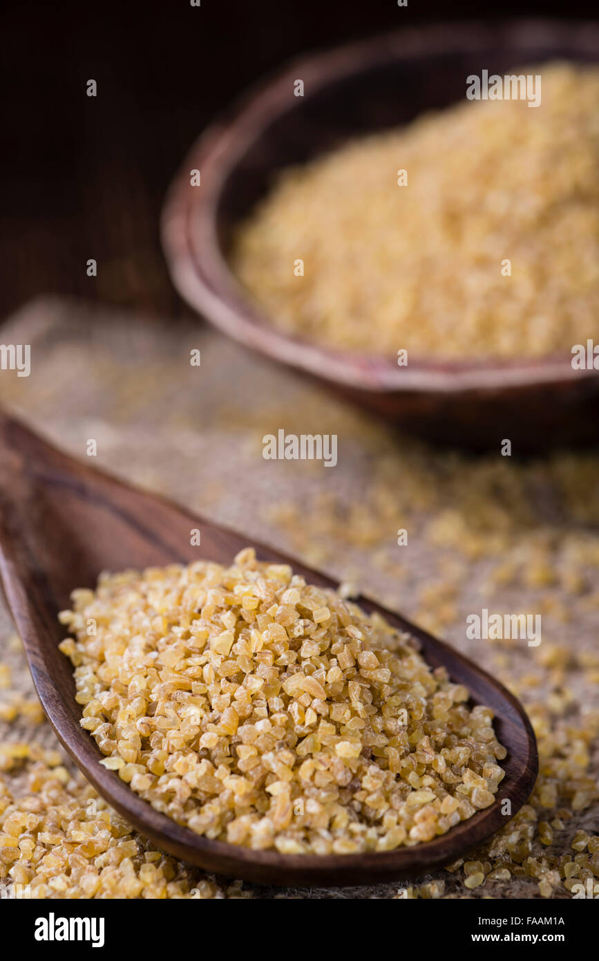 Portion of raw Bulgur (close-up shot) on wooden background Stock Photo ...