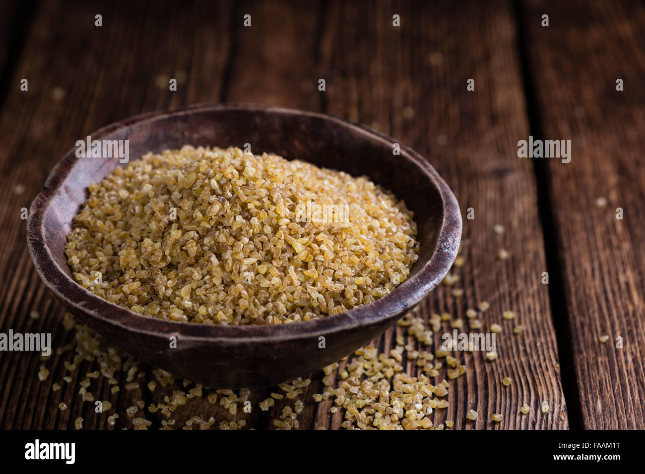 Raw Bulgur (on wooden background) as detailed close-up shot Stock Photo ...