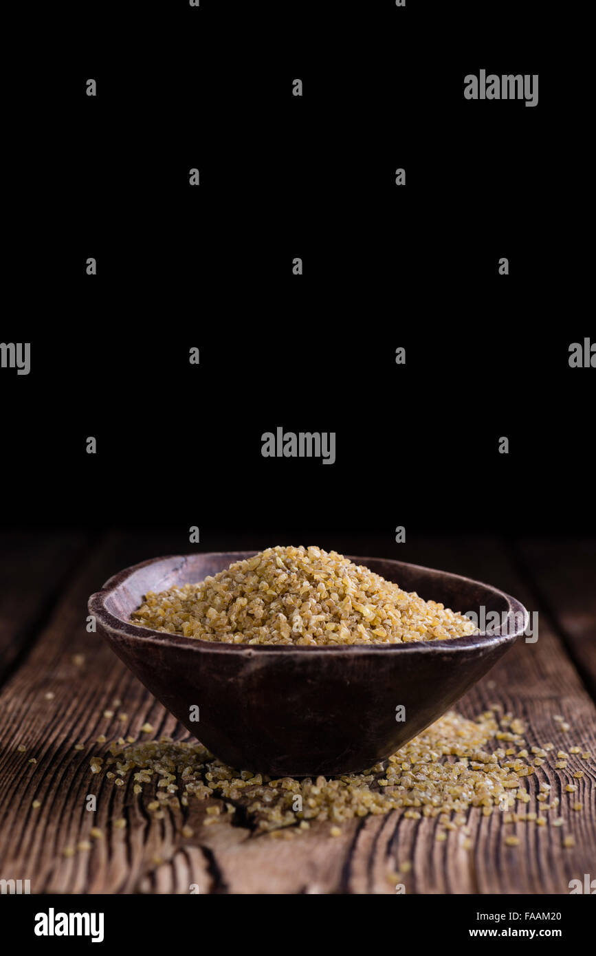 Raw Bulgur (on wooden background) as detailed close-up shot Stock Photo ...