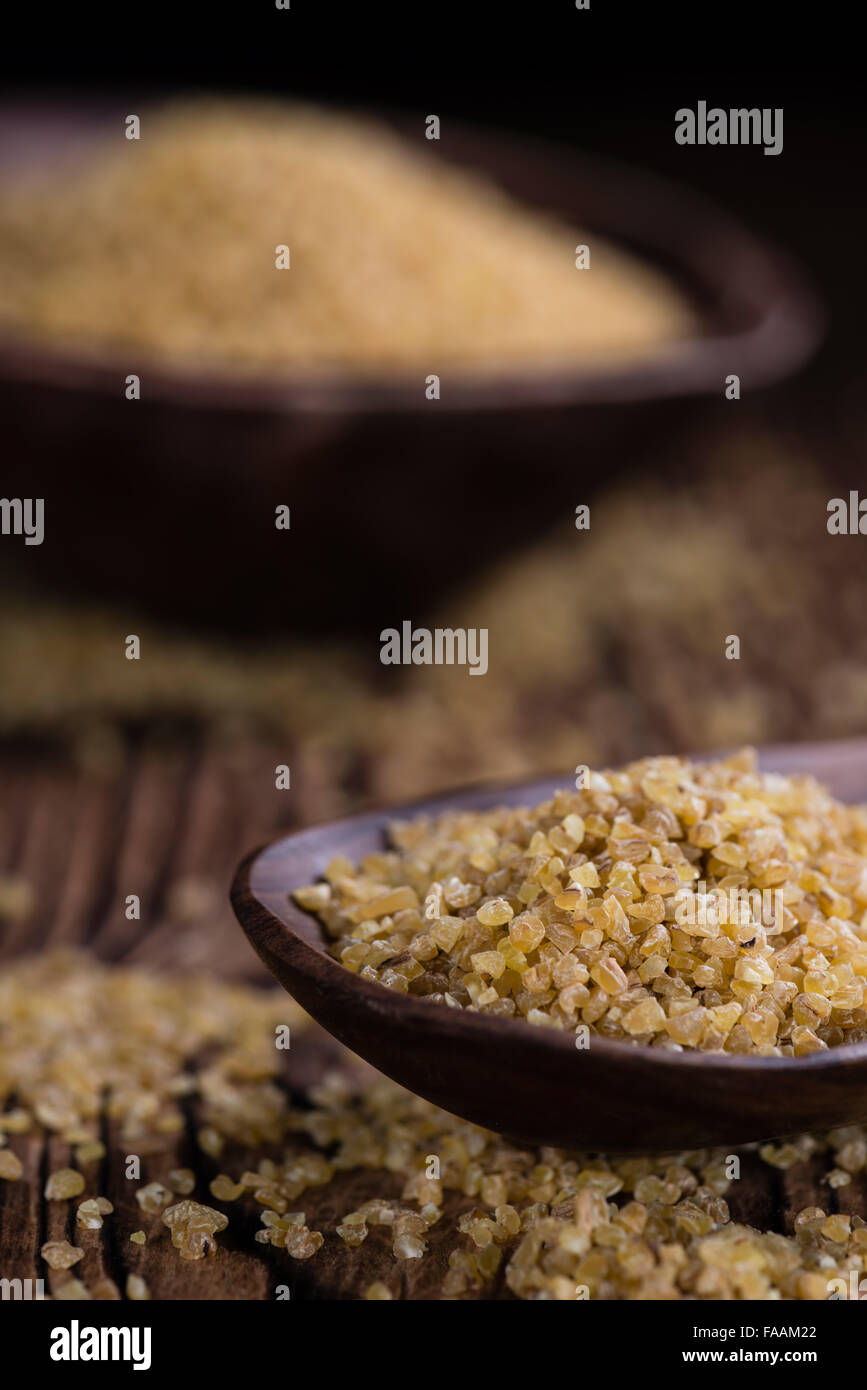 Raw Bulgur (on wooden background) as detailed close-up shot Stock Photo ...
