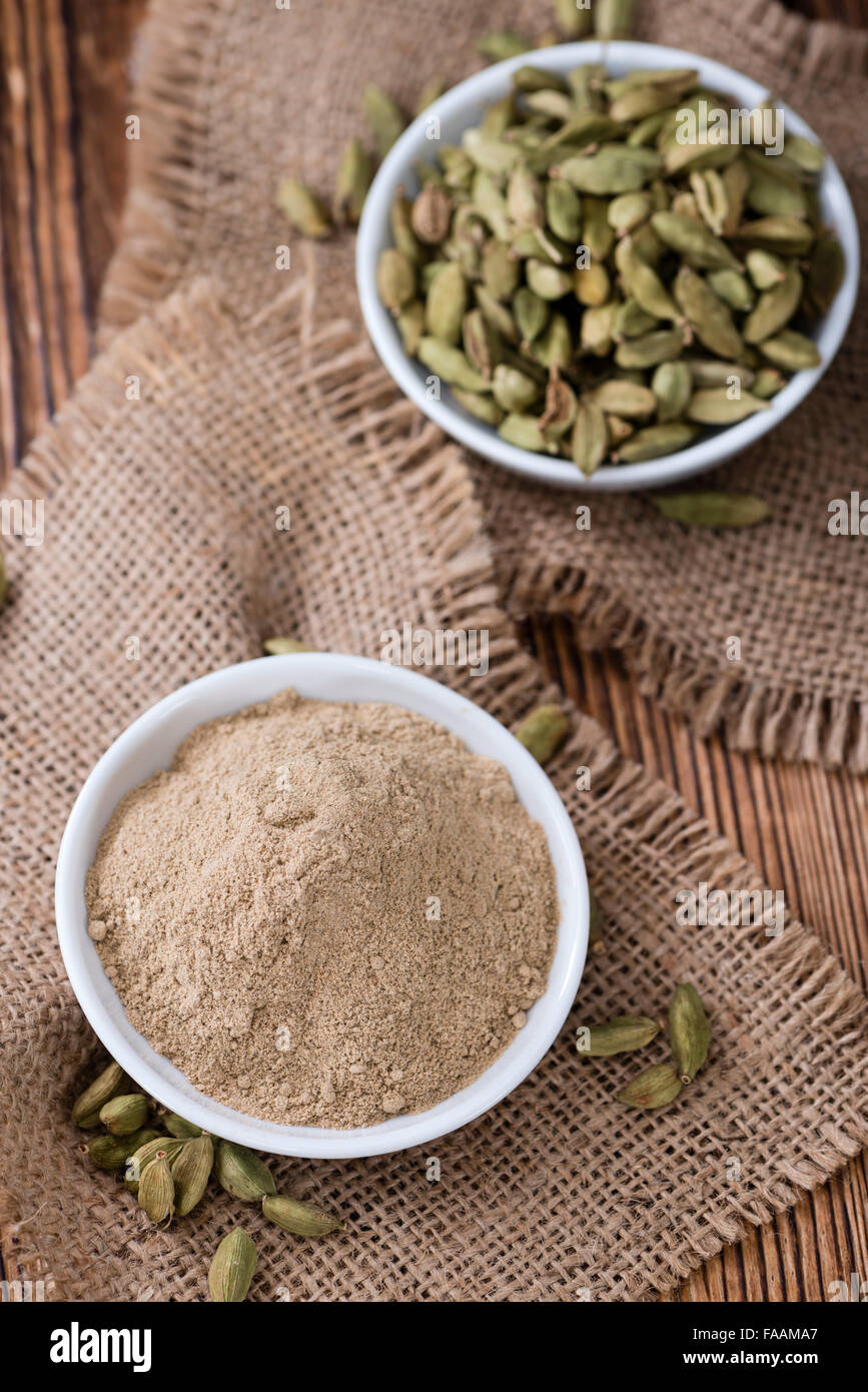 Heap of Cardamon Powder (close-up shot) on rustic wooden background ...