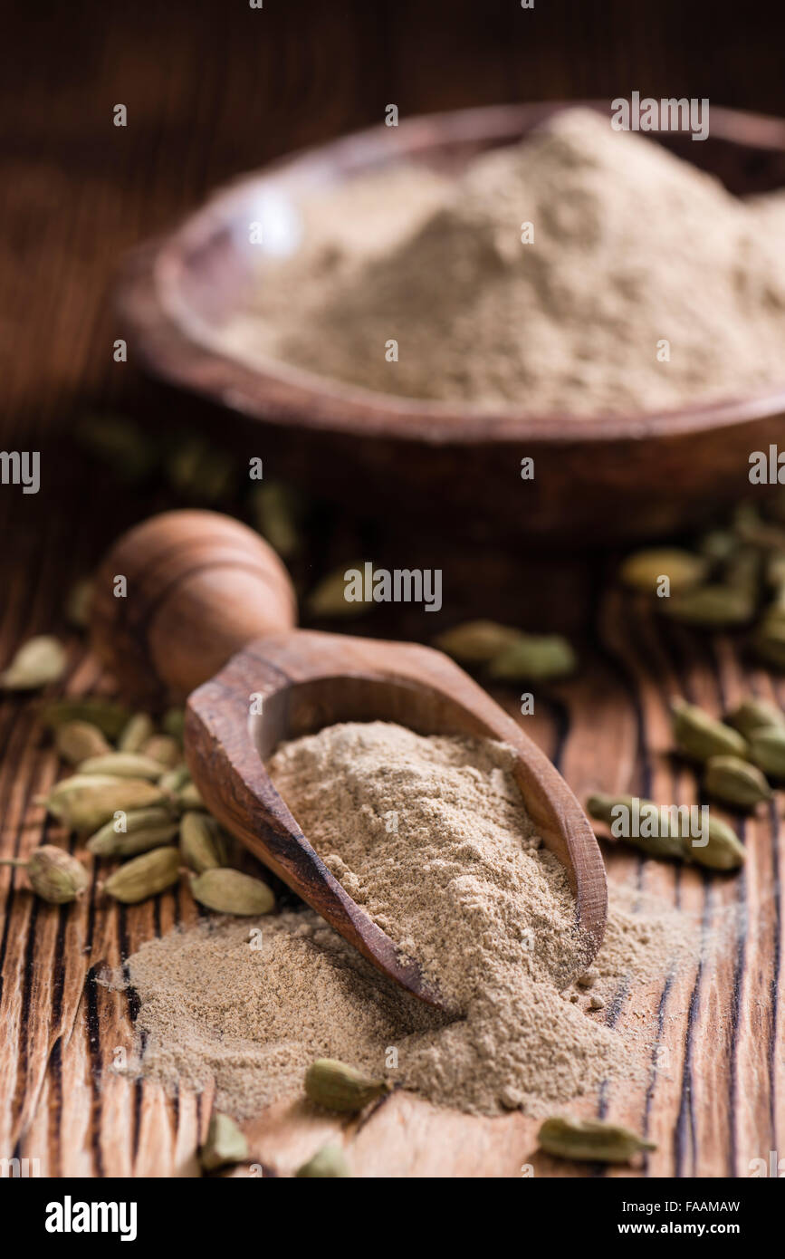 Heap of Cardamon Powder (close-up shot) on rustic wooden background ...