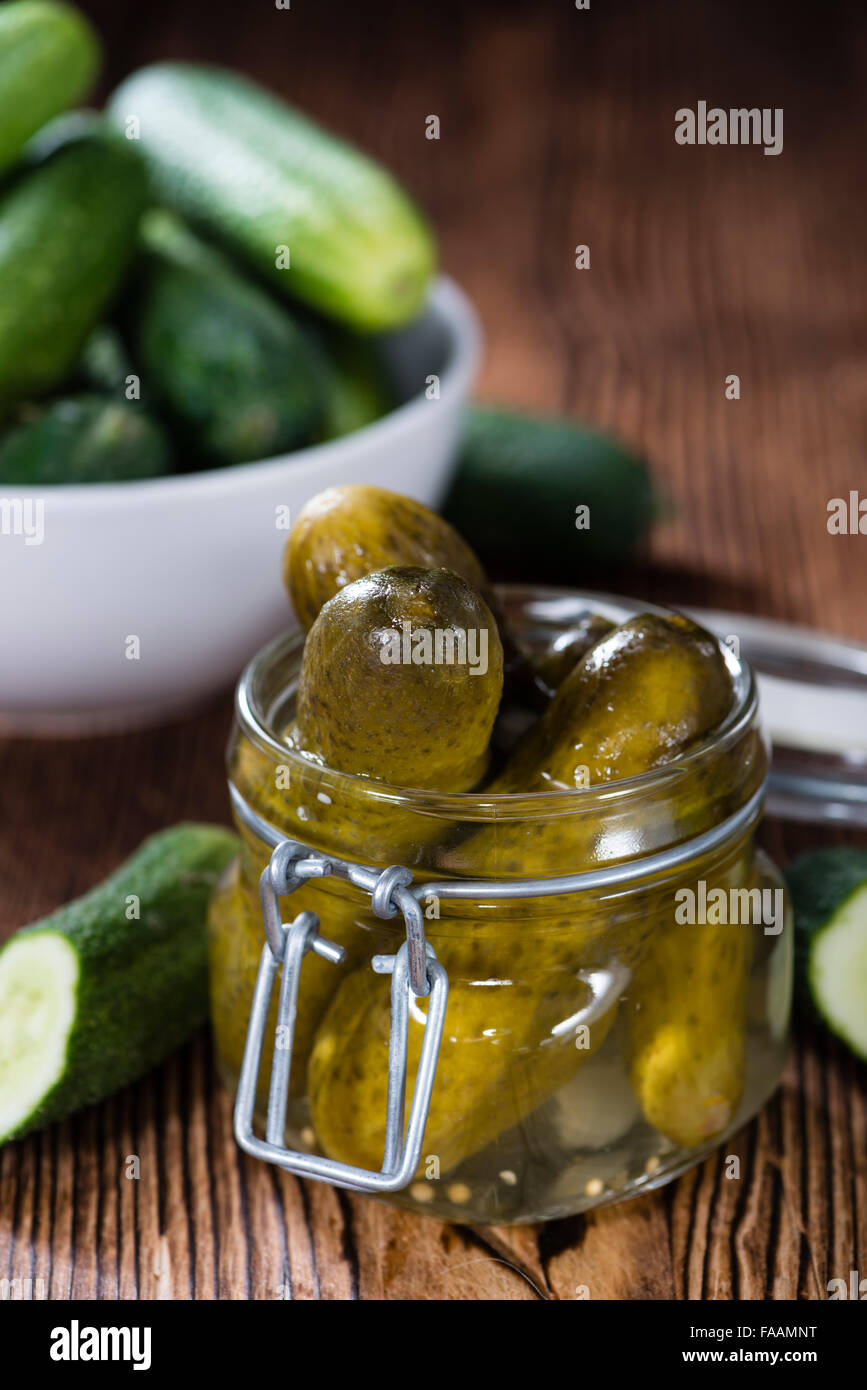 Preserved Gherkins (on wooden background) as detailed close-up shot ...