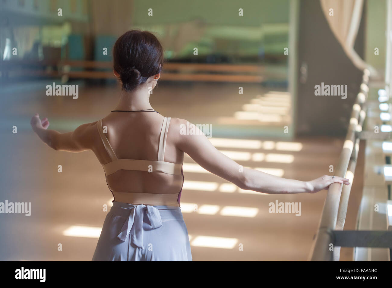 classic ballet dancer posing at barre on rehearsal room background ...