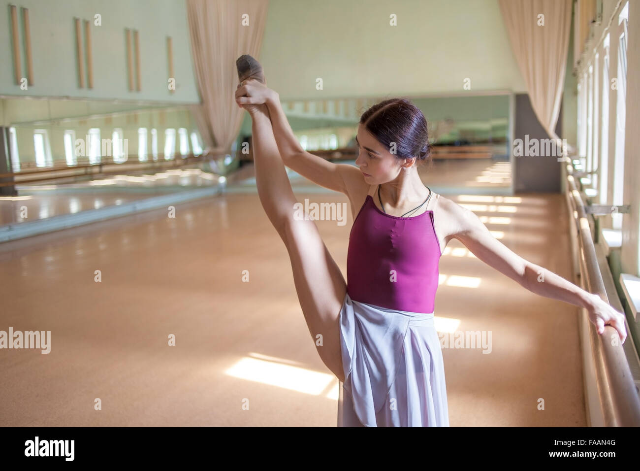 classic ballet dancer posing at barre on rehearsal room background ...