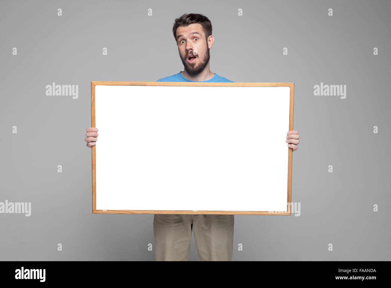 The surprised man showing empty white billboard or banner Stock Photo ...