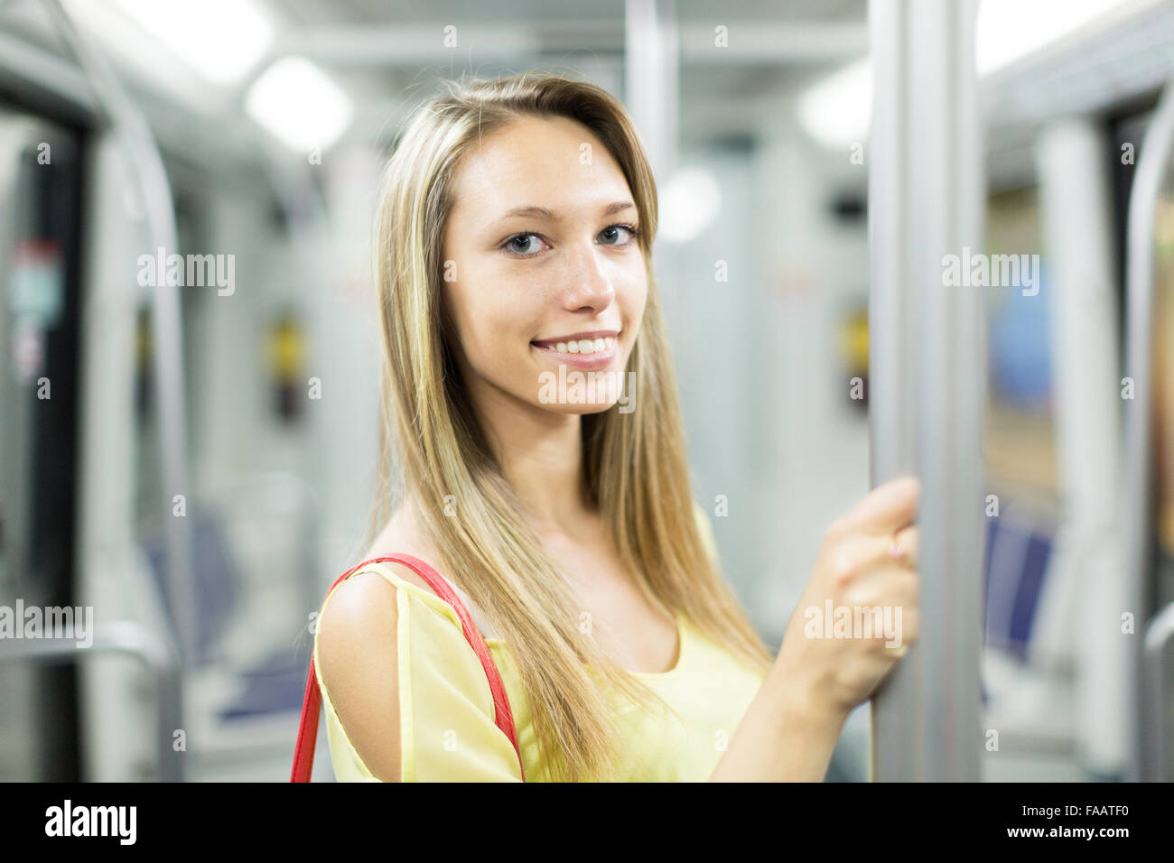 Casual smiling female passanger in train of metro Stock Photo - Alamy