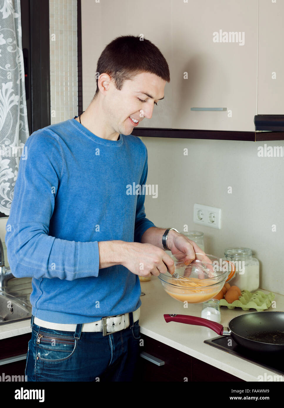 Man making scrambled eggs in frying pan at home kitchen Stock Photo - Alamy