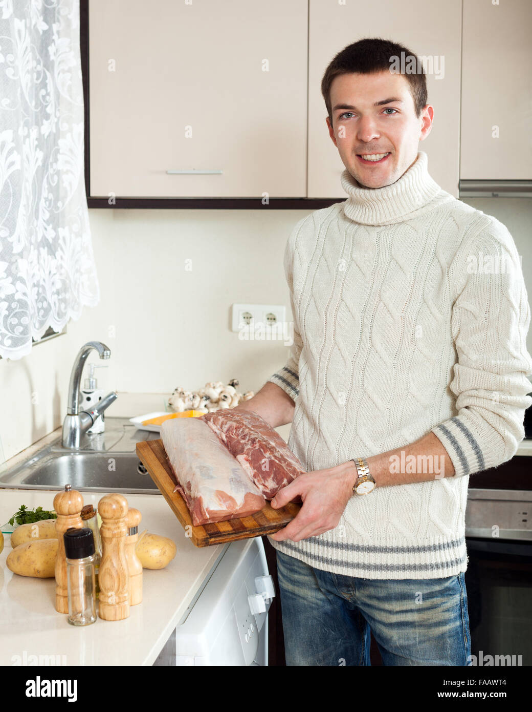 Ordinary young man holding raw meat in home kitchen Stock Photo - Alamy
