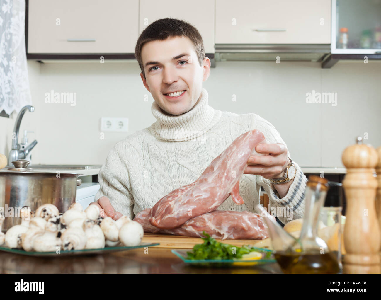 Handsome man cooking french-style meat in roasting pan Stock Photo - Alamy