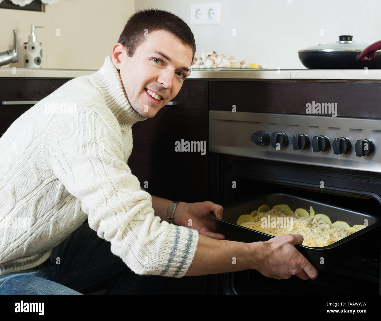 Happy handsome man cooking meat in domestic kitchen Stock Photo - Alamy