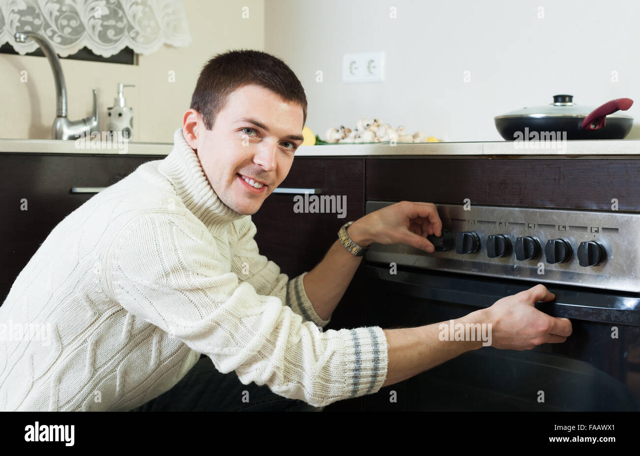man cooking something in the oven in home kitchen Stock Photo - Alamy