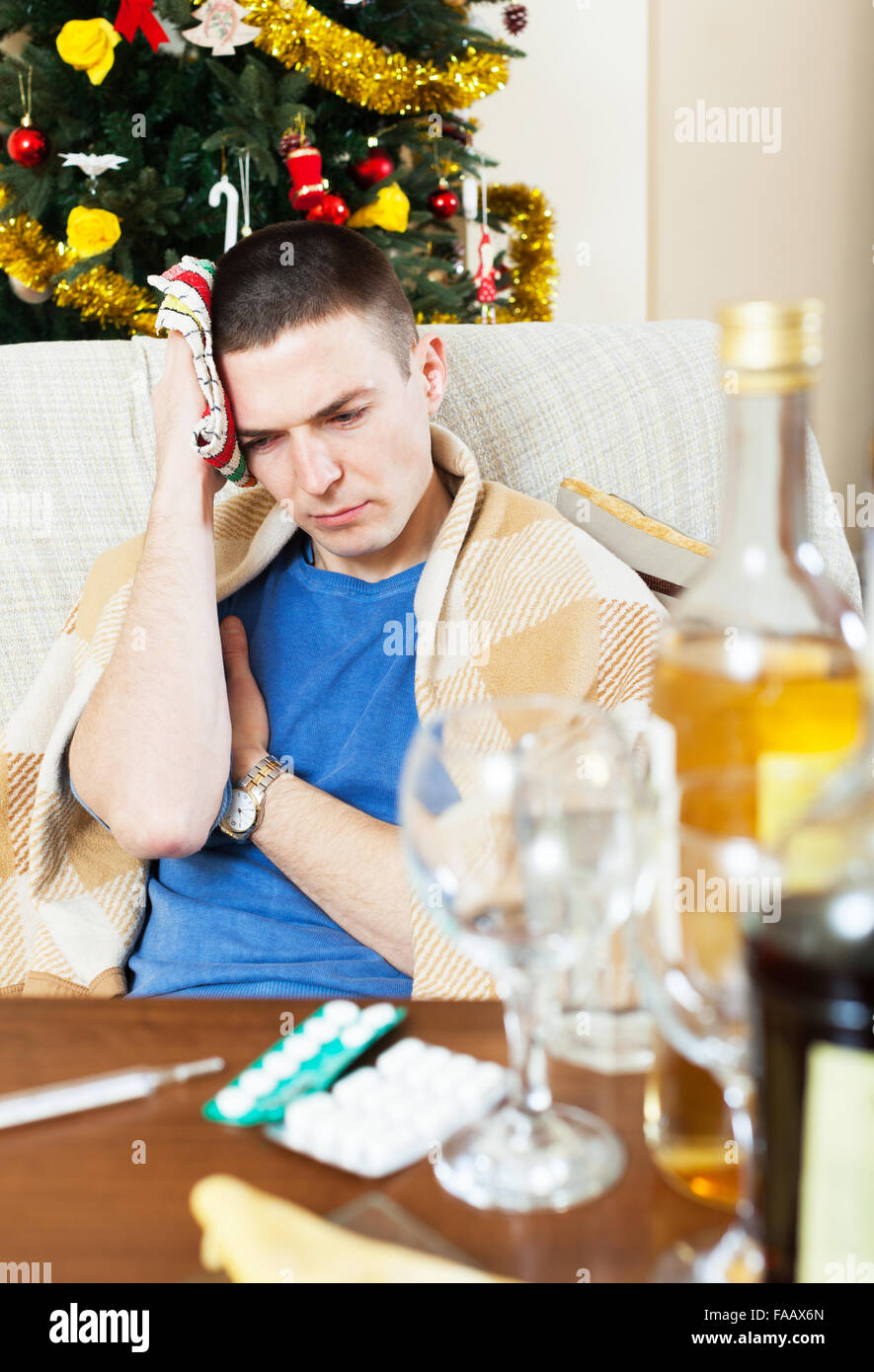 Suffering sick guys with hangover sitting by the tanle with medication ...