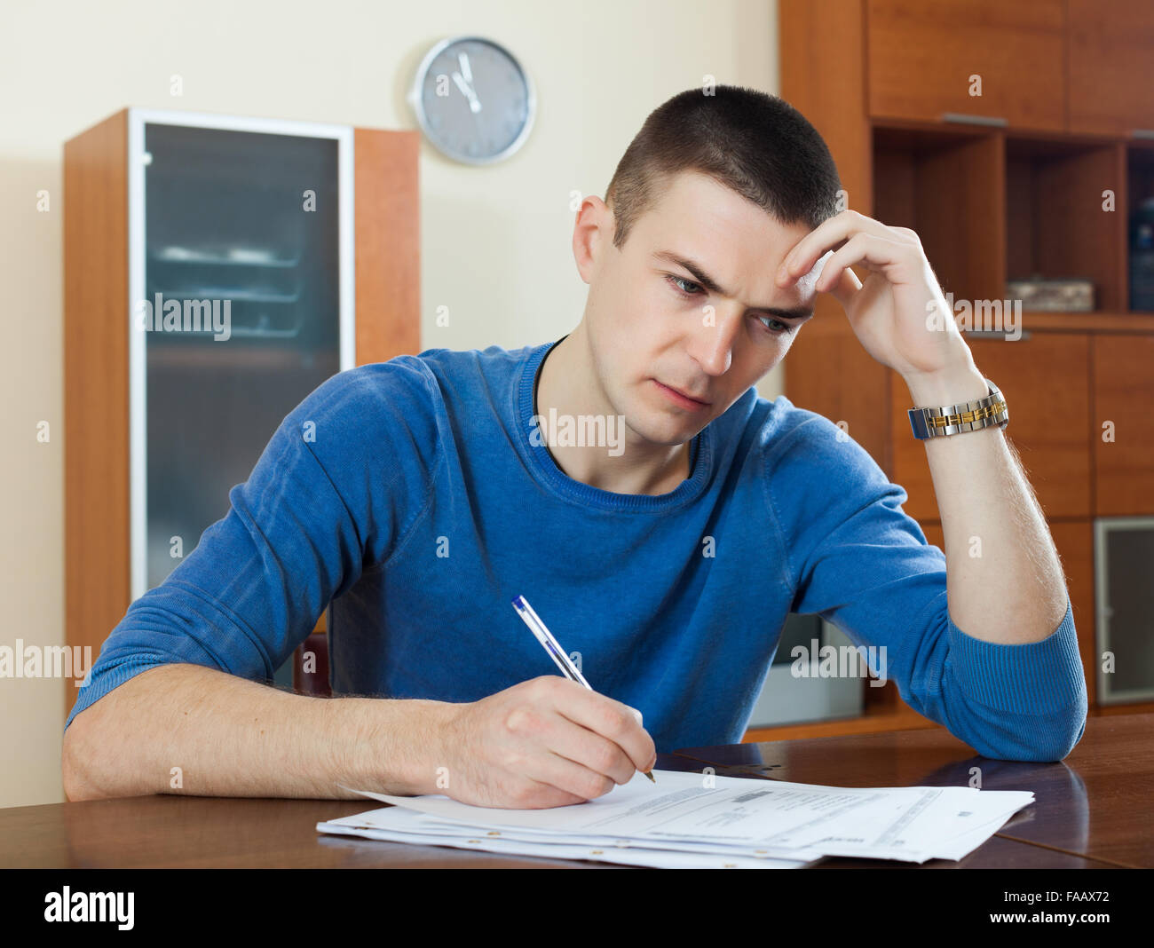 man fills in the questionnaire at home interior Stock Photo - Alamy