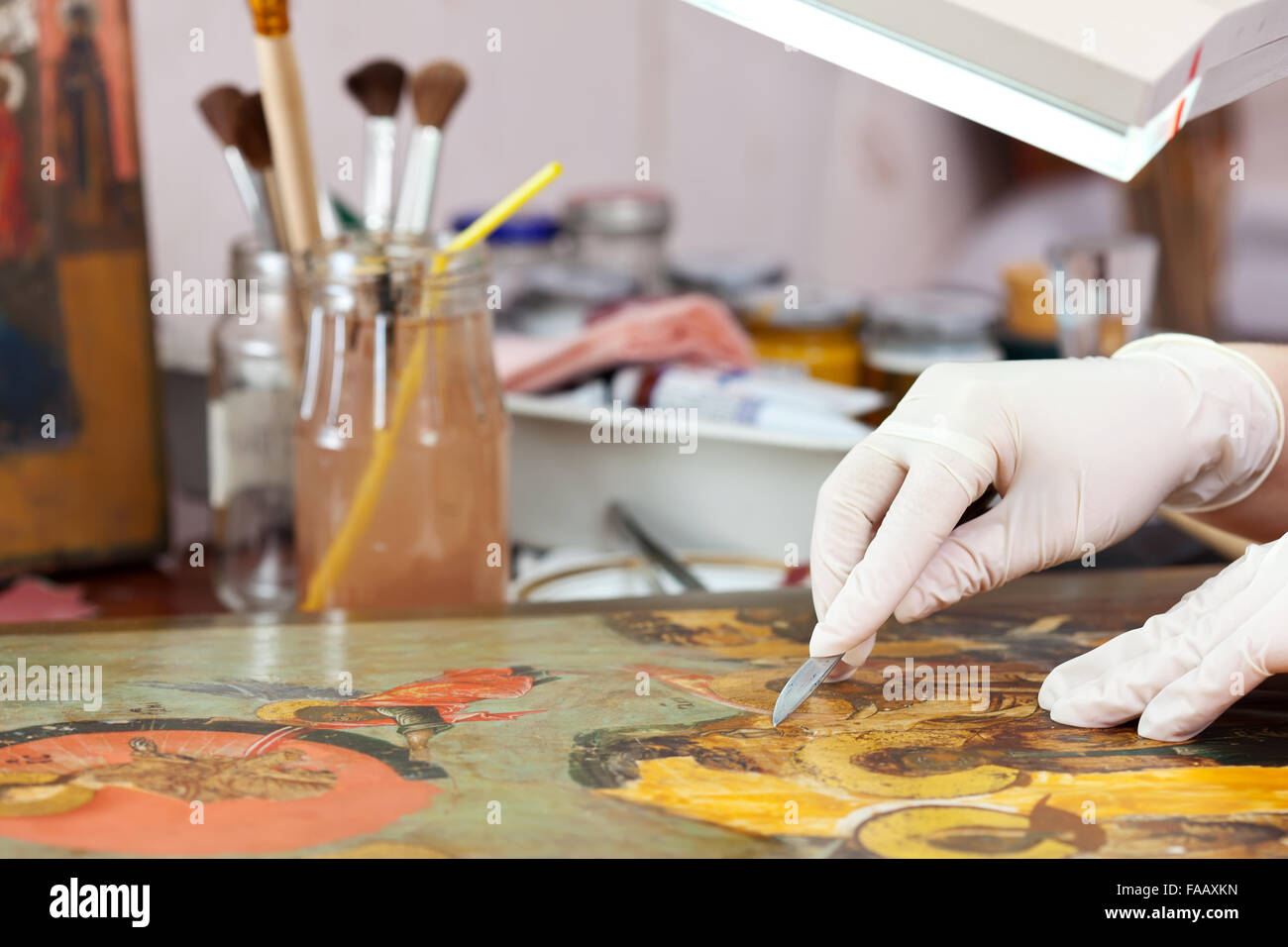Restorer working on the ancient Christian icon at restoration workshop ...