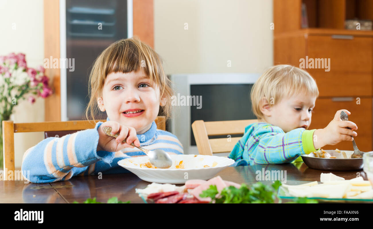 children eating food from plates in home interior Stock Photo - Alamy