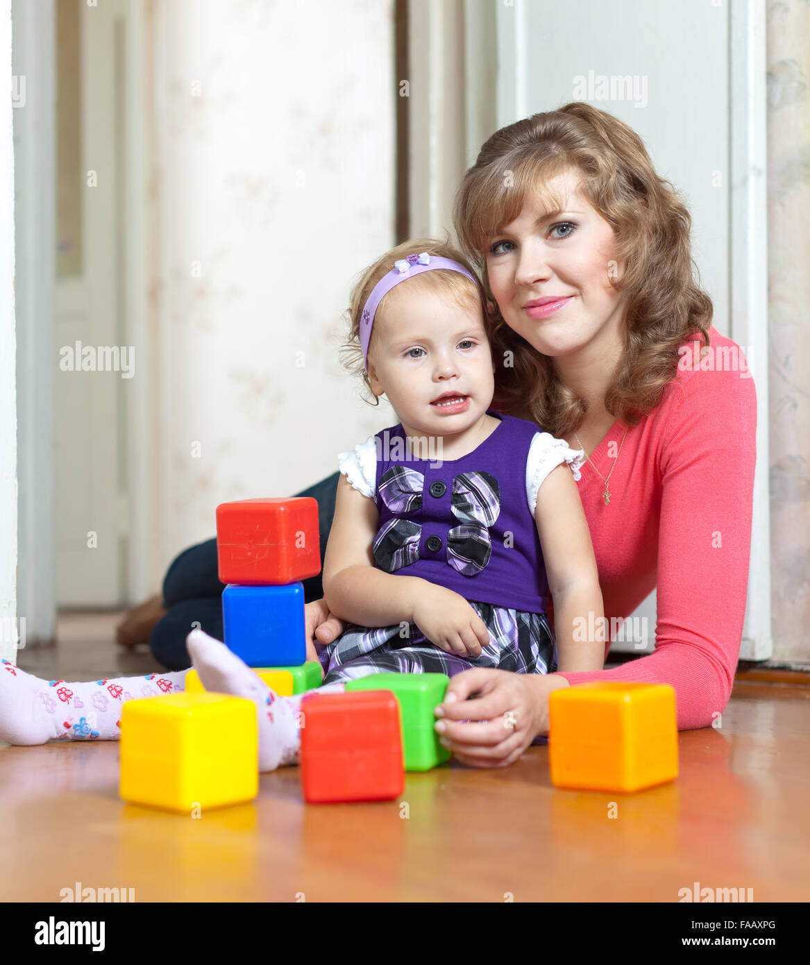Happy mother plays with baby in home interior Stock Photo - Alamy