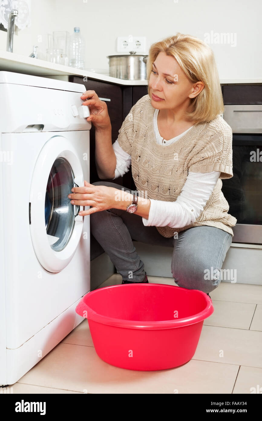 Home laundry. Smiling mature woman using washing machine at home Stock ...