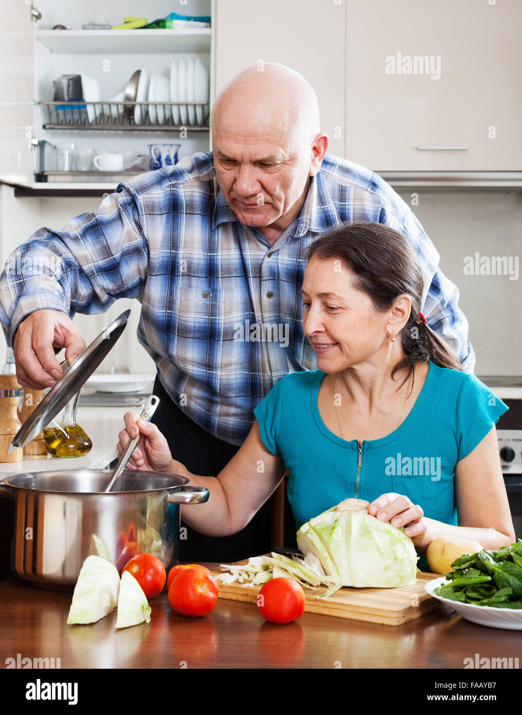 senior couple cooking together in domestic kitchen Stock Photo - Alamy