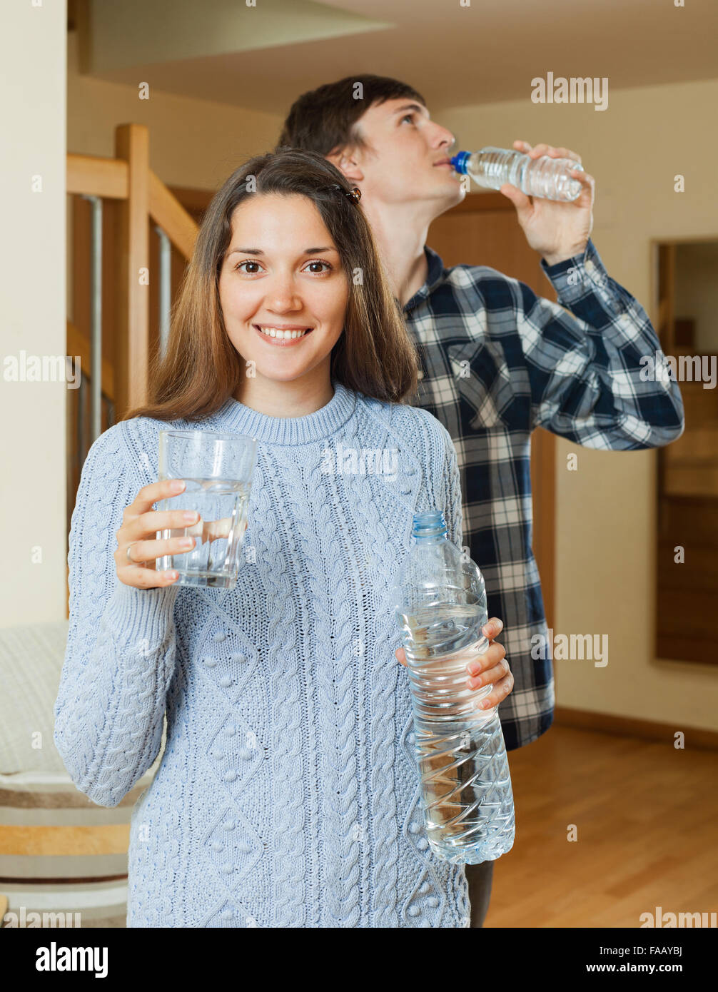 Happy young people drinking clean water in home Stock Photo - Alamy