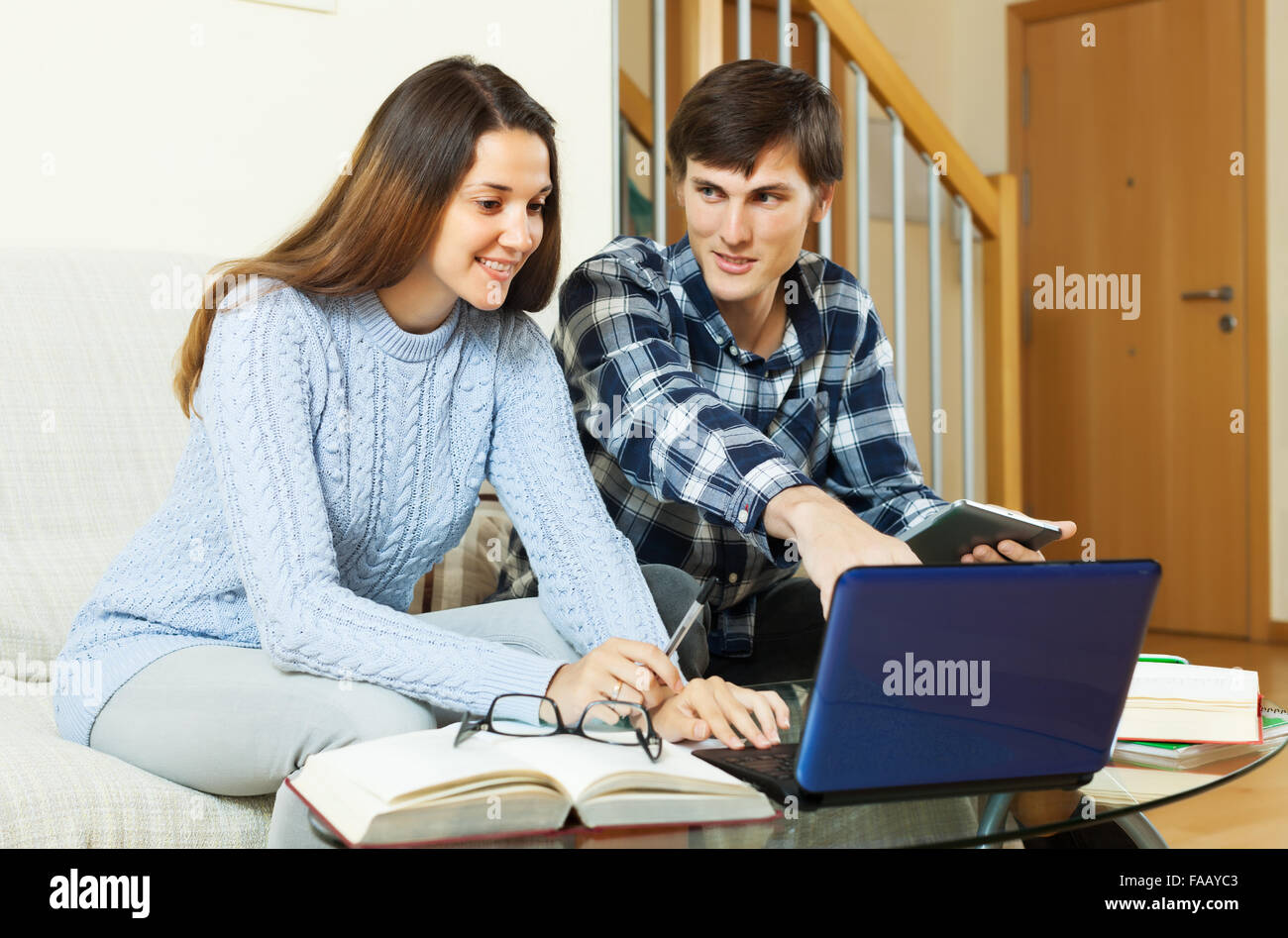 student couple doing homework with laptop at home Stock Photo - Alamy