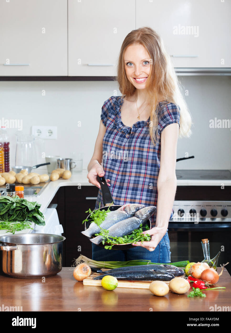 Happy blonde girl cooking fish hi-res stock photography and images - Alamy