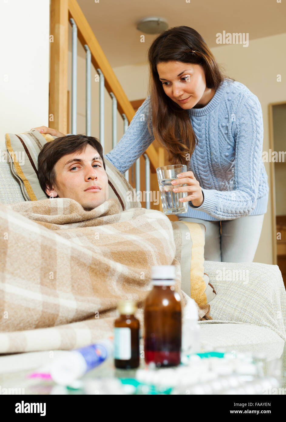 Pretty girl caring for sick husband in room Stock Photo - Alamy