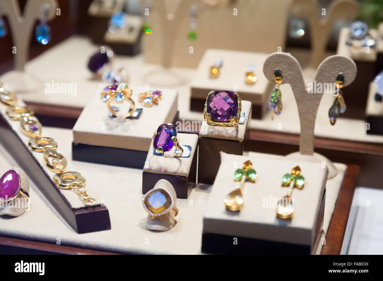 Gold rings with gems on jewelry counter in store Stock Photo - Alamy