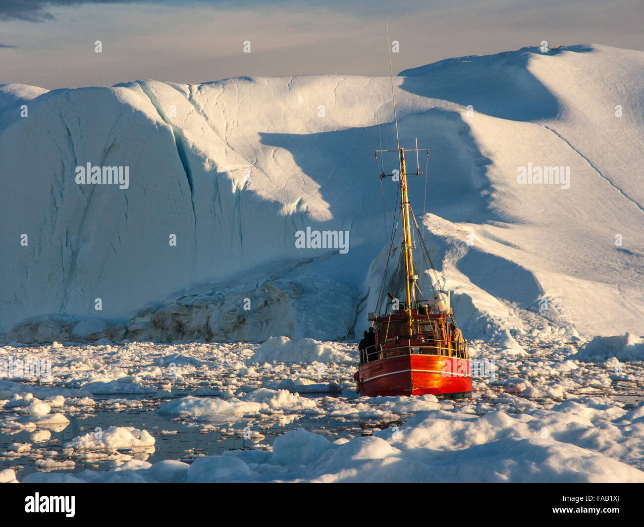 Fishing boat approaches giant iceberg, Ilulissat, Greenland Stock Photo ...