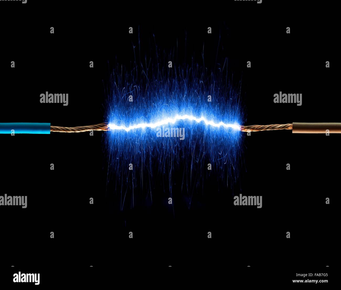 Wires connected by blue sparks against a black background Stock Photo ...