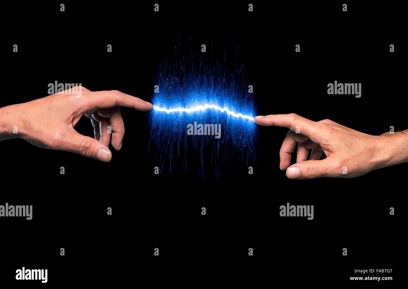 Fingers connected by blue sparks against a black background Stock Photo ...