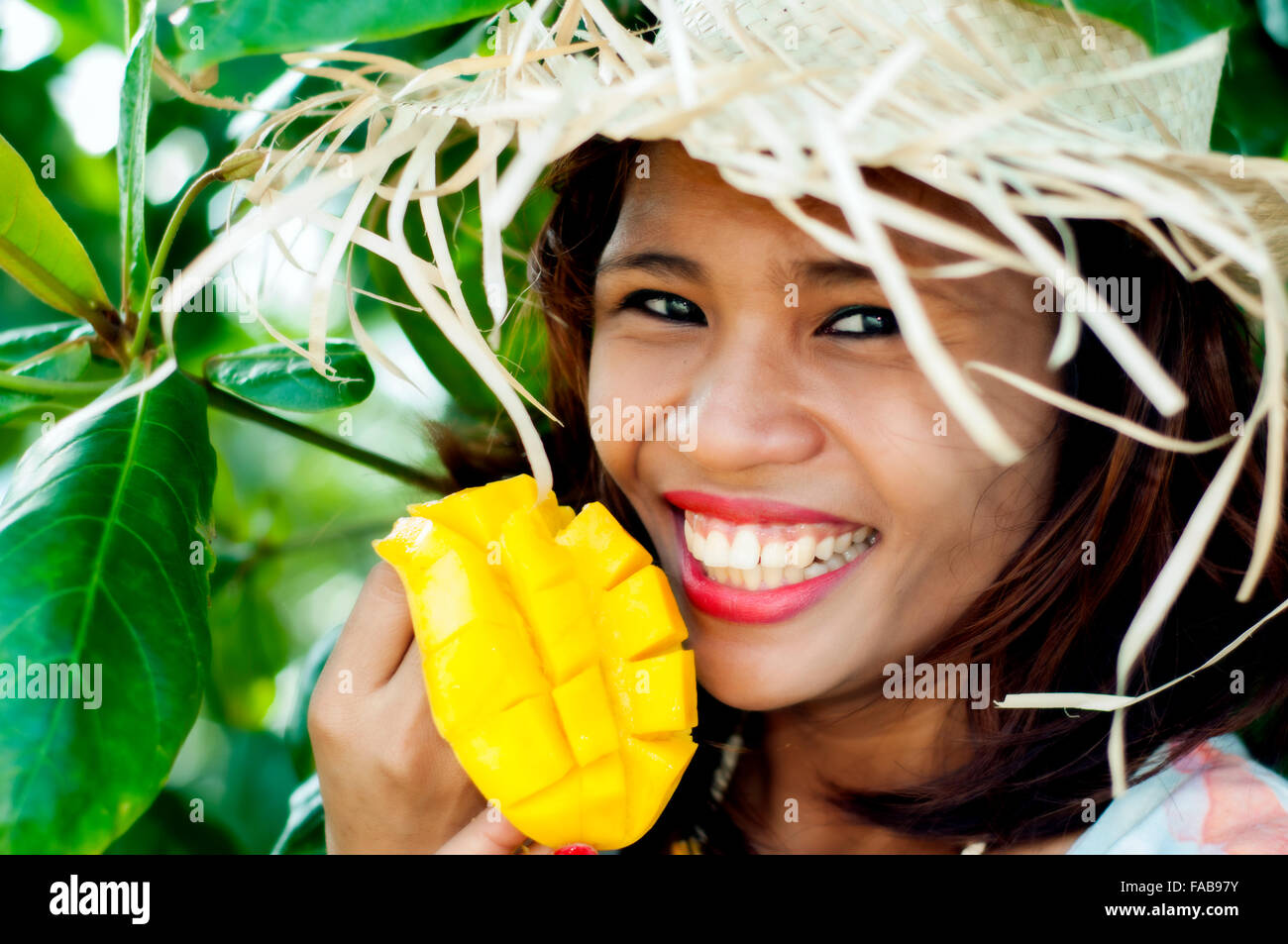 Young Asian woman with fresh mango, on location, Cebu, Philippines ...