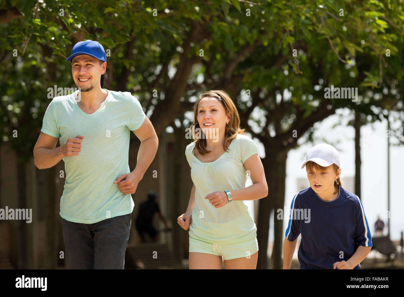 Happy family with child running in park and smiling Stock Photo - Alamy
