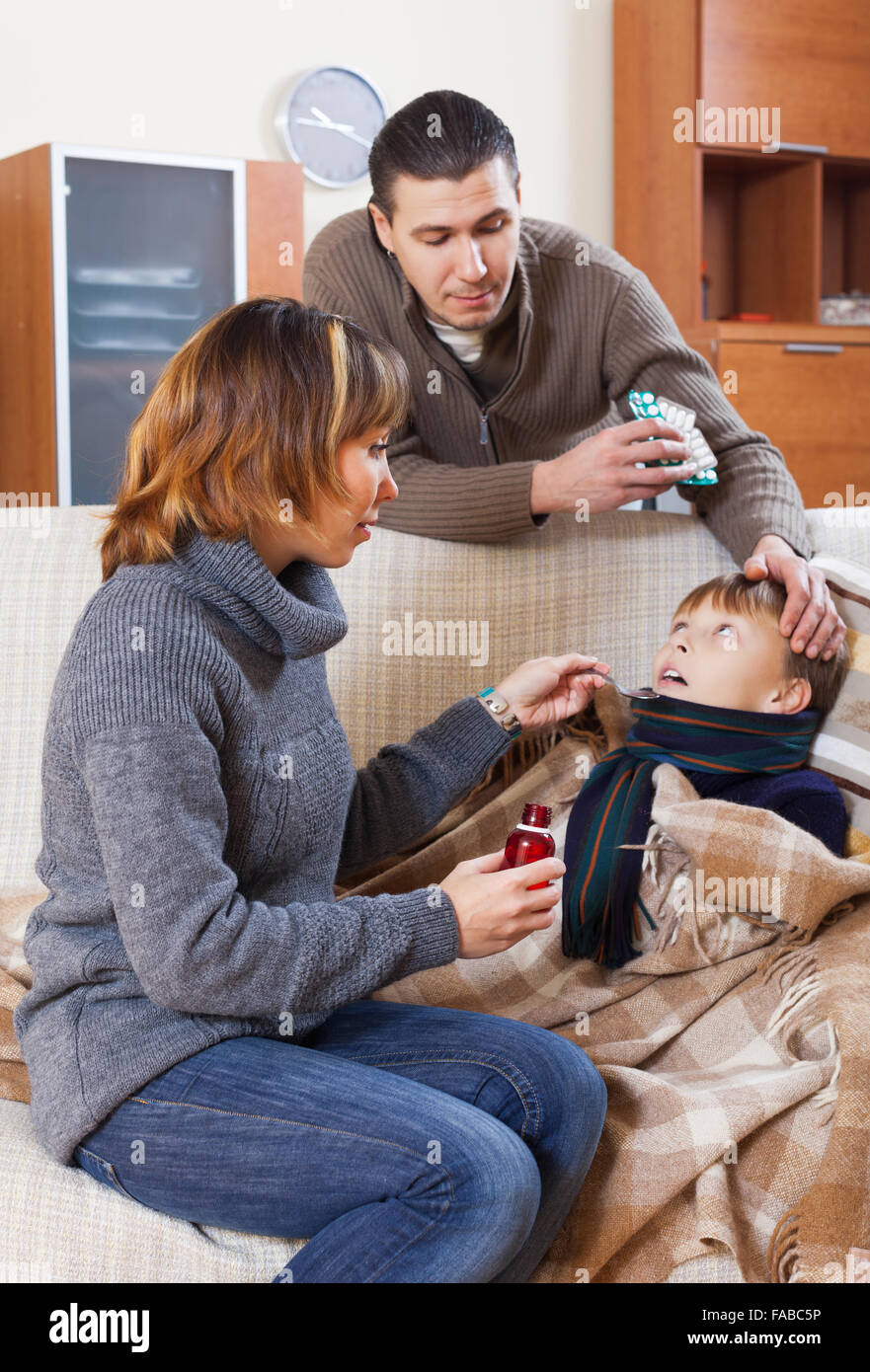 Parents giving medicinal sirup to teenager at home Stock Photo - Alamy