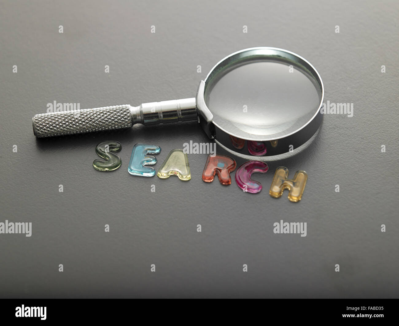 alphabet search beside of magnifying glass Stock Photo - Alamy