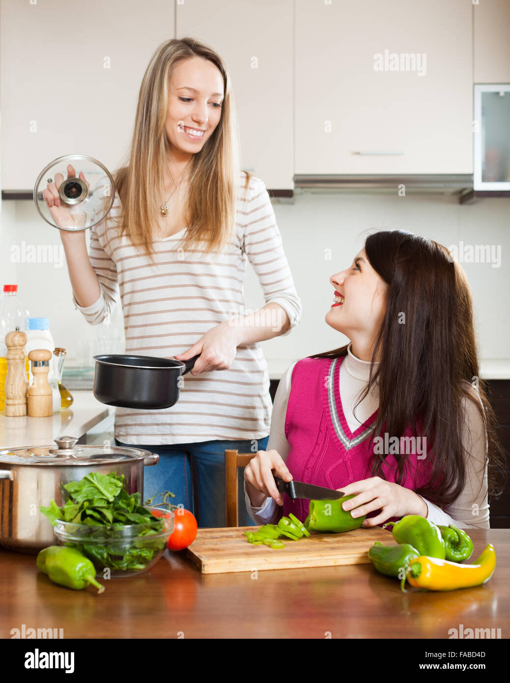 Two happy women cooking something together at them kitchen Stock Photo ...