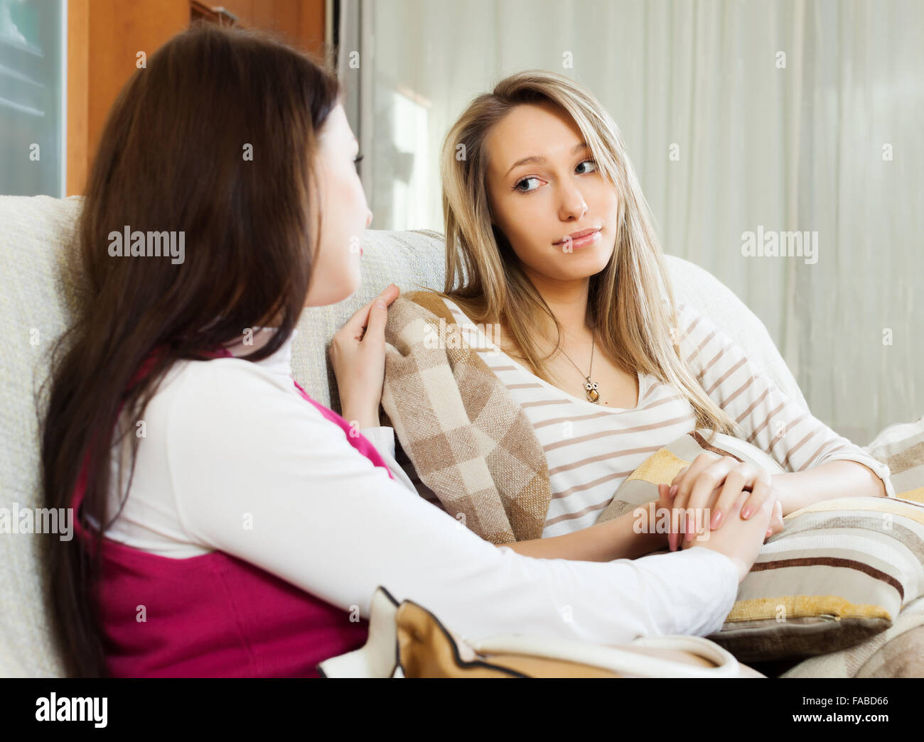 woman comforting crying friend at sofa in home Stock Photo - Alamy