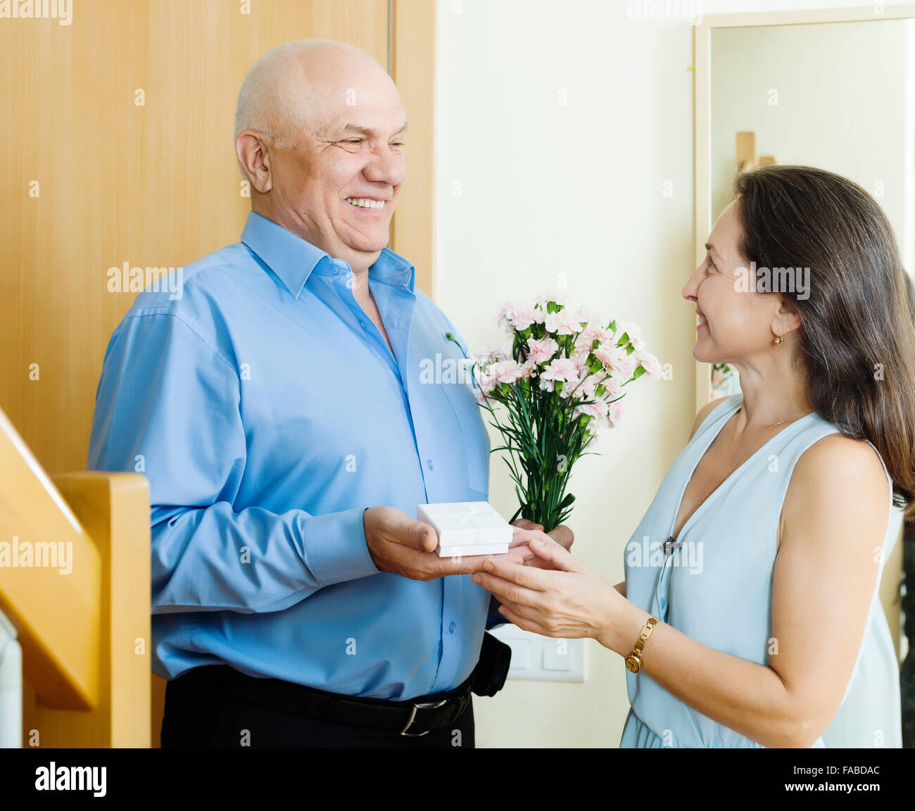 Smiling mature man giving jewel to woman at home door Stock Photo - Alamy