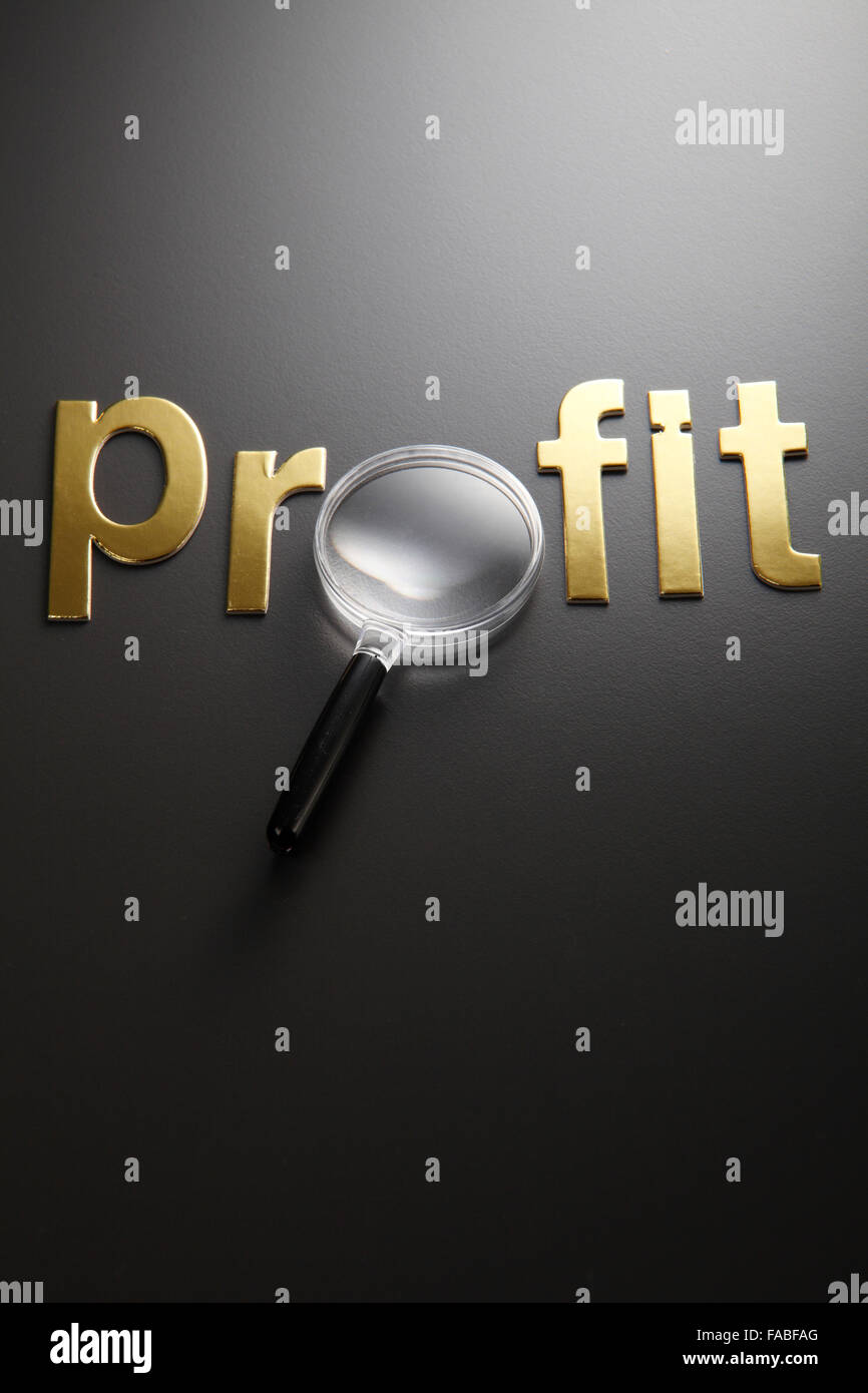 profit and magnifying glass on the gray background Stock Photo - Alamy