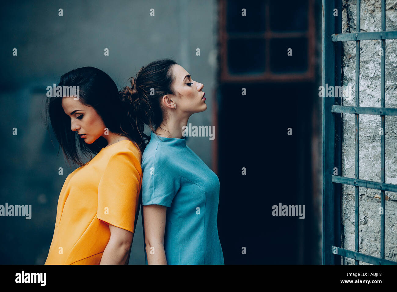 Two young beautiful girls posing against the backdrop of an abandoned ...