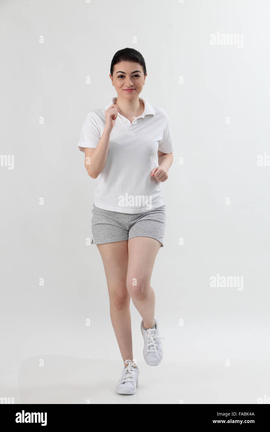 Studio portrait of young woman jogging Stock Photo - Alamy