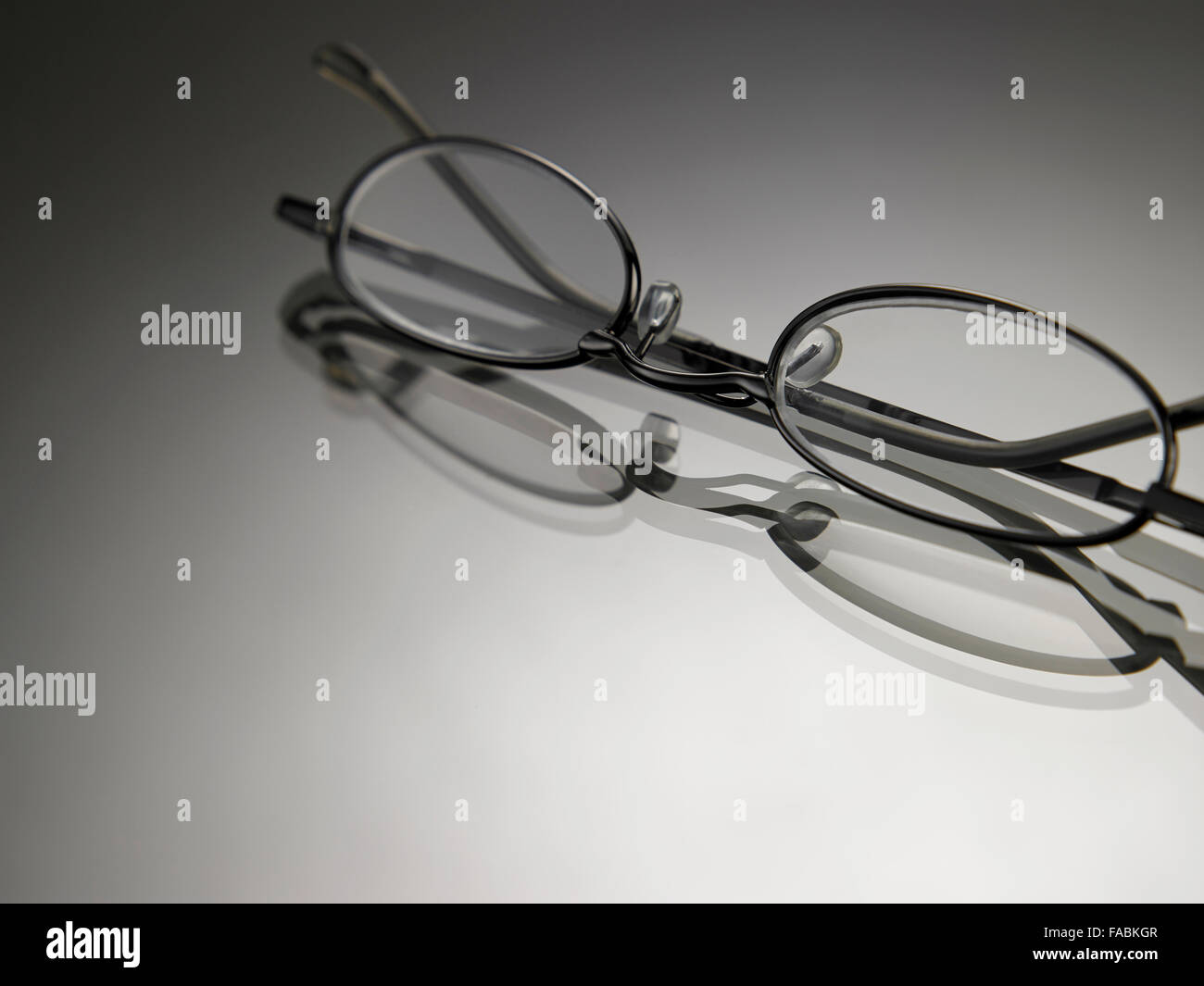 reading glass on the gray background with reflection Stock Photo - Alamy
